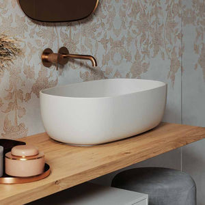 Countertop washbasin - CONCAVE - PLANIT - Corian® / oval / without hole